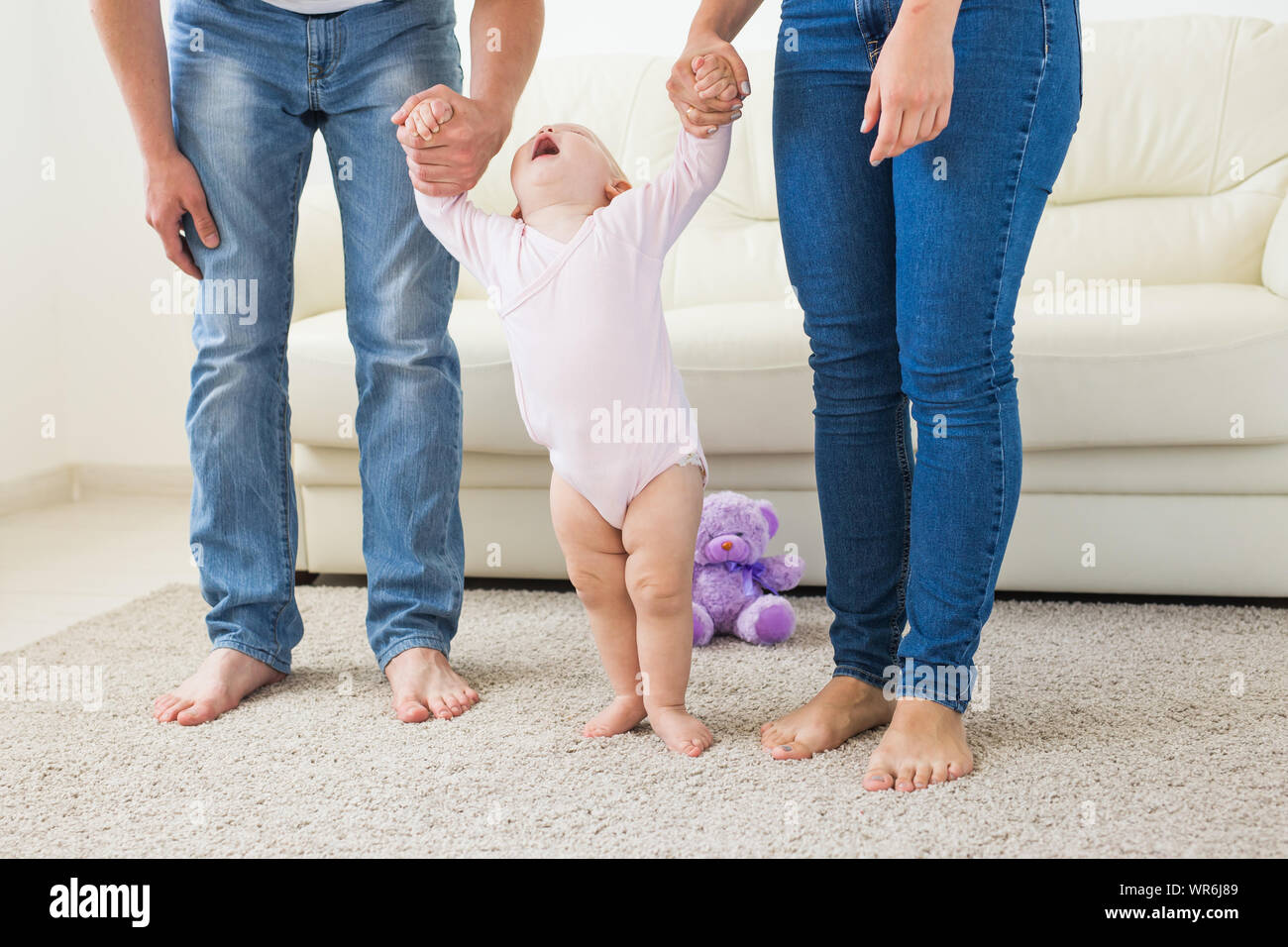 First steps. Little baby girl learning to walk. Studio shoot on white ...