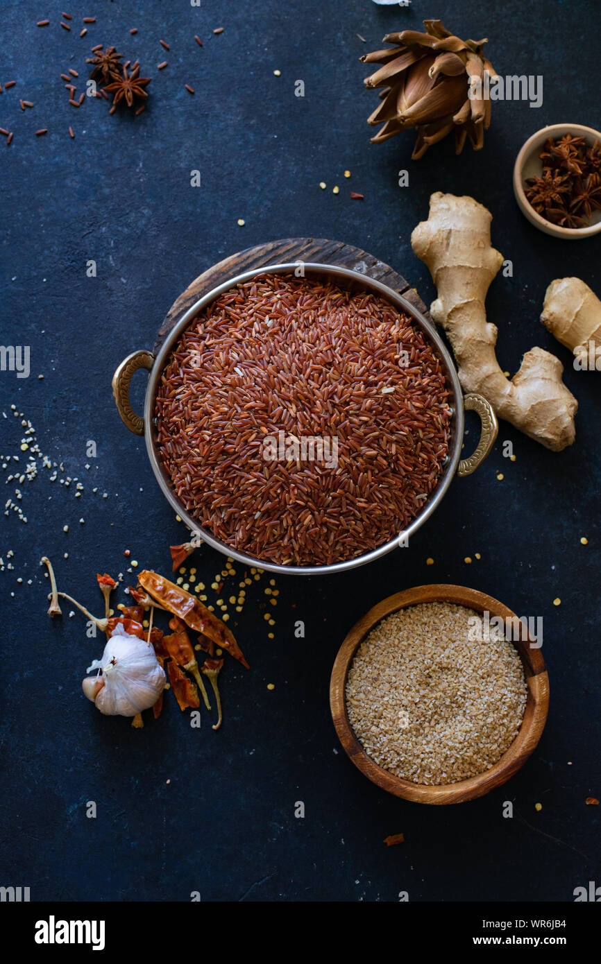 Various types of rice and grains with spices on blue background. Brown ...