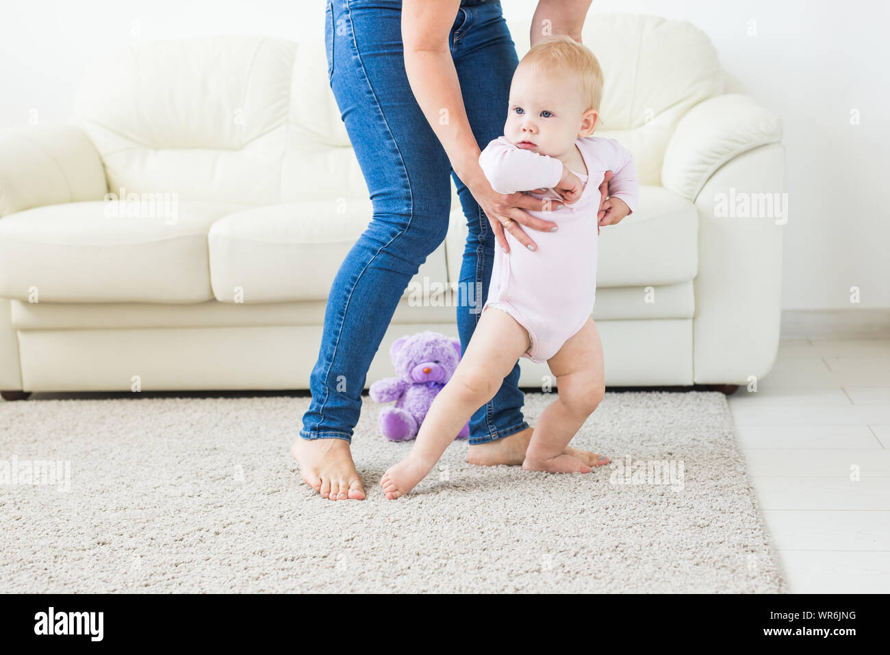 First steps. Little baby girl learning to walk. Studio shoot on white ...
