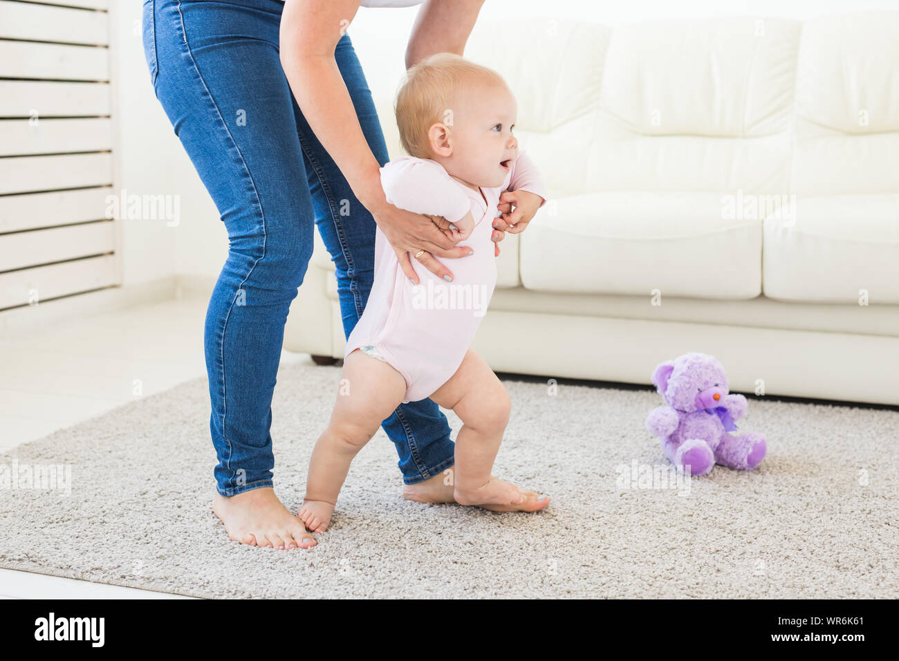 First steps. Little baby girl learning to walk. Studio shoot on white ...