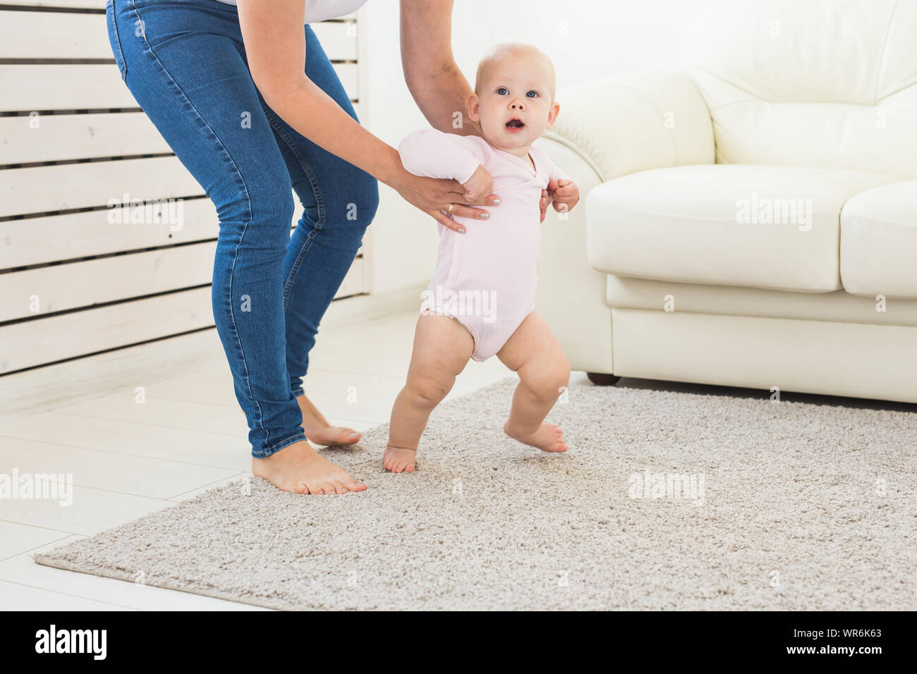 First steps. Little baby girl learning to walk. Studio shoot on white ...