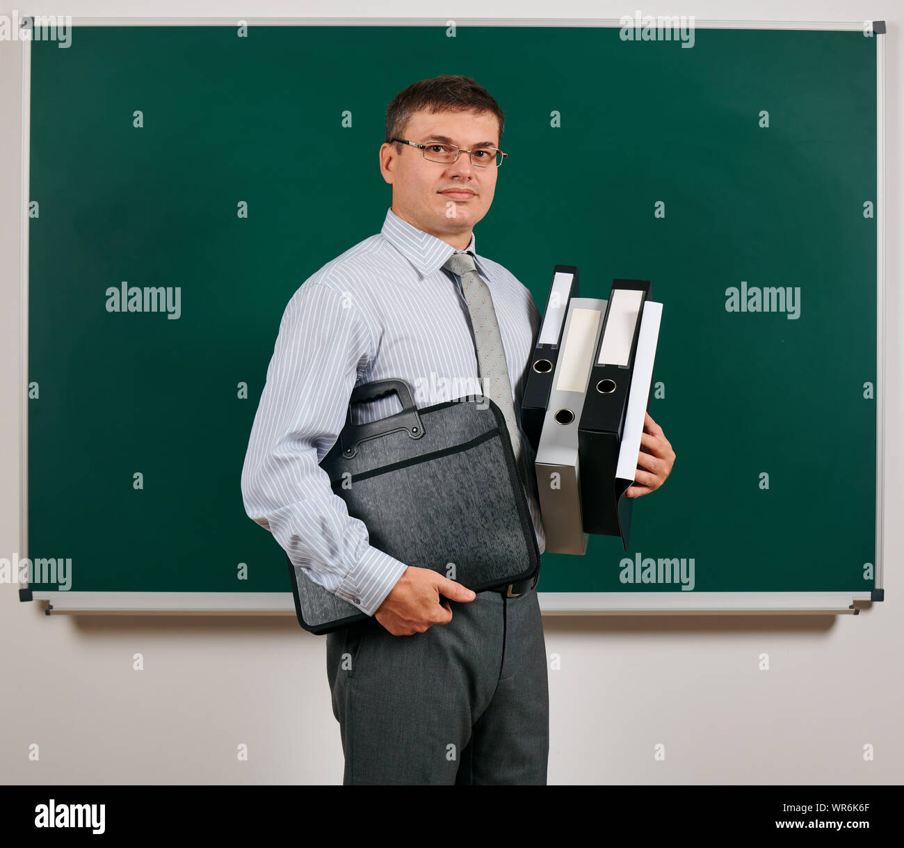 Portrait of a men dressed in business suit with folders, documents and ...