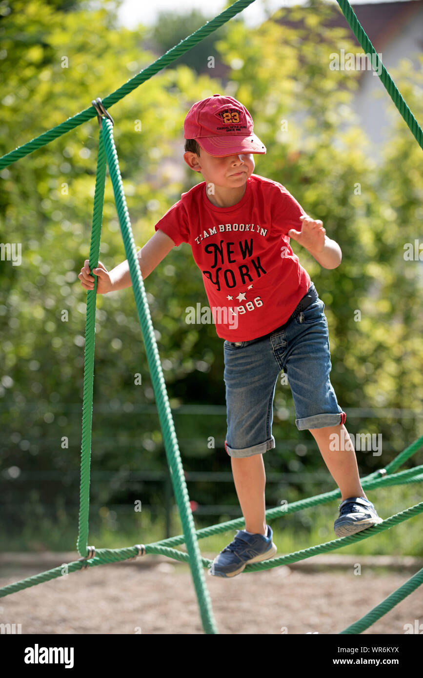 Young boy climbing on a spider web Stock Photo - Alamy