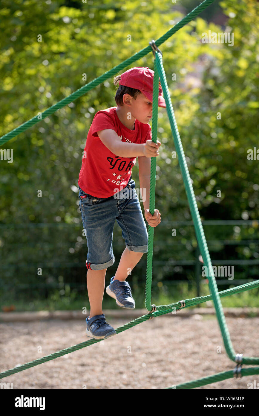 Young boy climbing on a spider web Stock Photo - Alamy