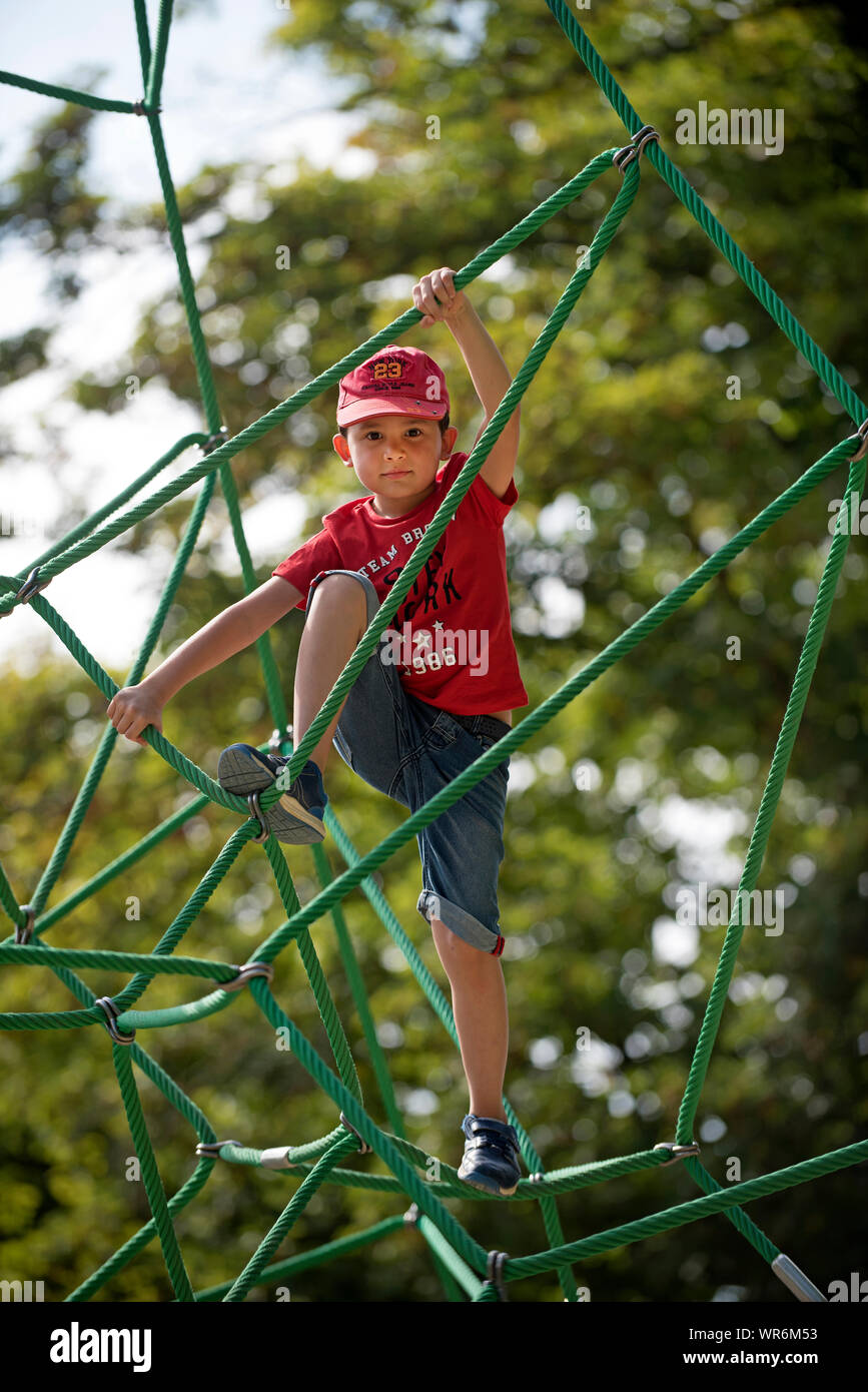 Young boy climbing on a spider web Stock Photo - Alamy