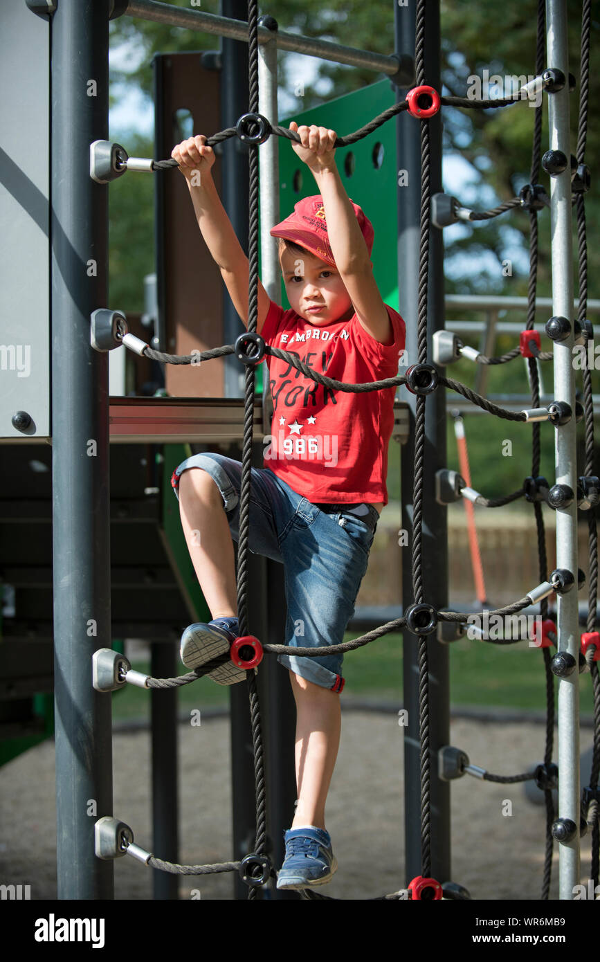 Young boy climbing on a rope ladder Stock Photo - Alamy