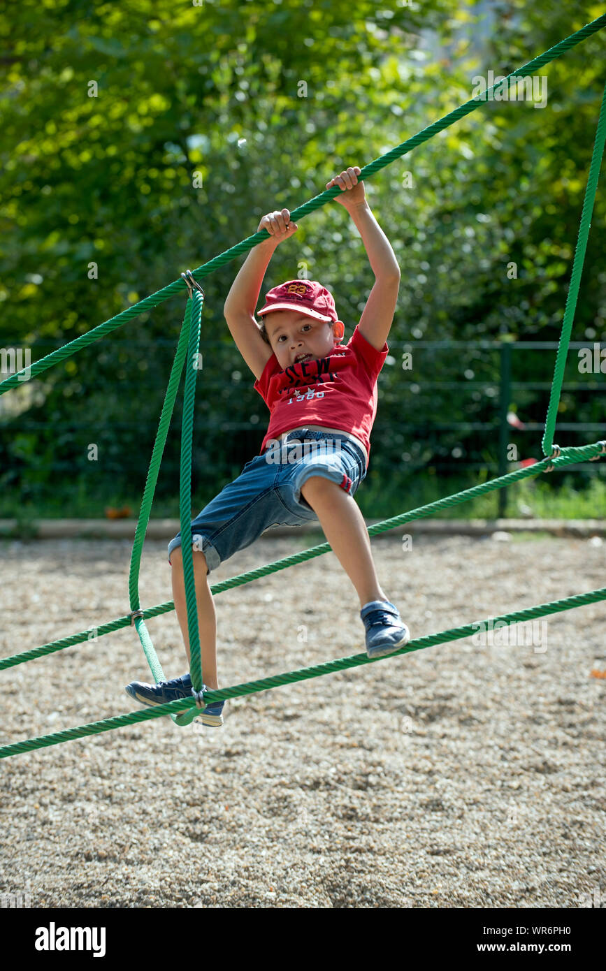 Young boy climbing on a spider web Stock Photo - Alamy