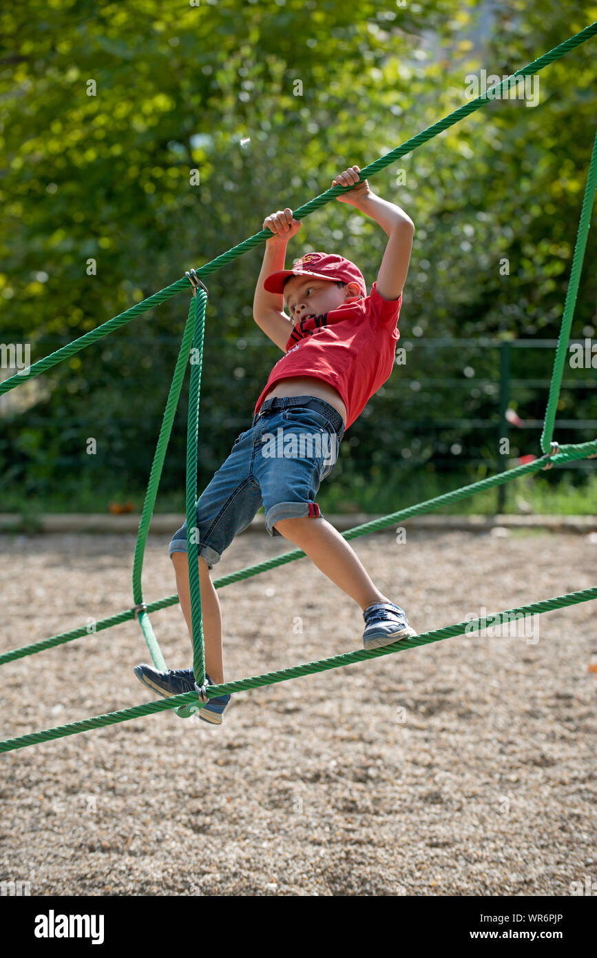 Young boy climbing on a spider web Stock Photo - Alamy