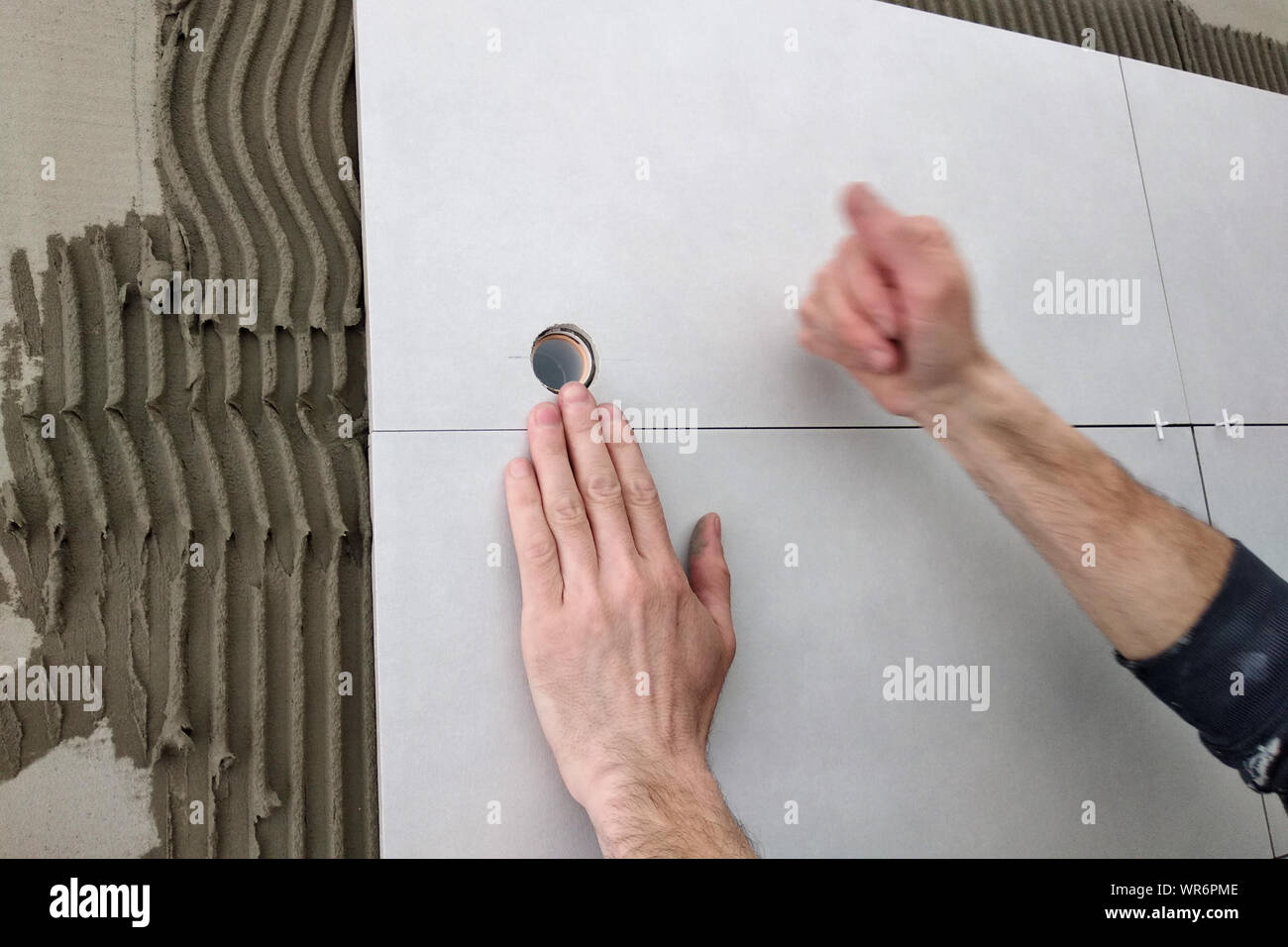 Worker hands putting ceramic tiles on the wall Stock Photo - Alamy
