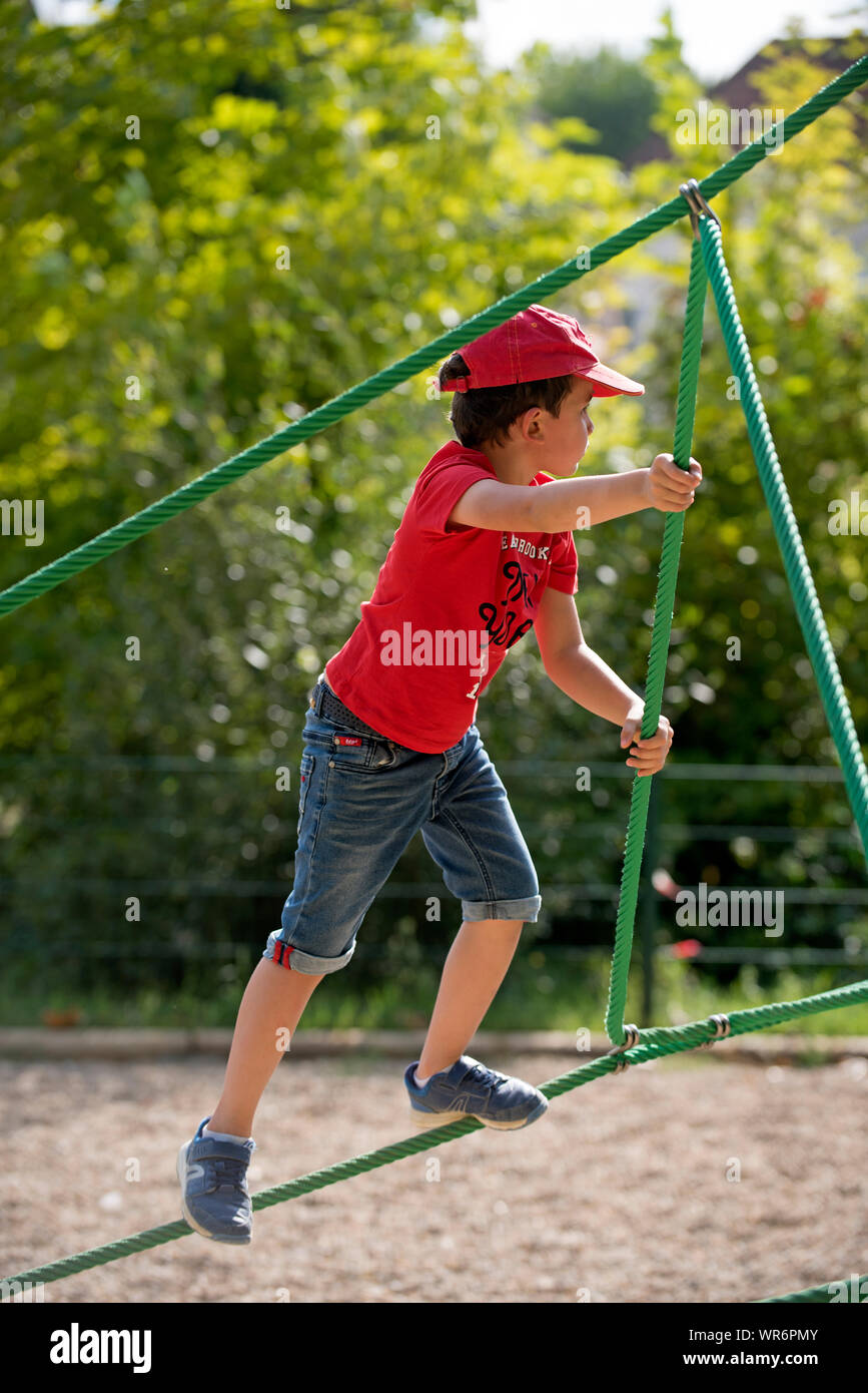 Young boy climbing on a spider web Stock Photo - Alamy