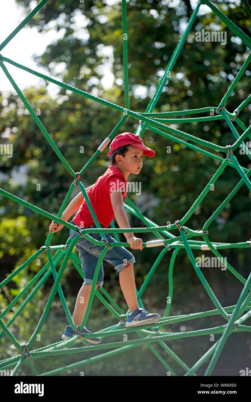 Young boy climbing on a spider web Stock Photo - Alamy