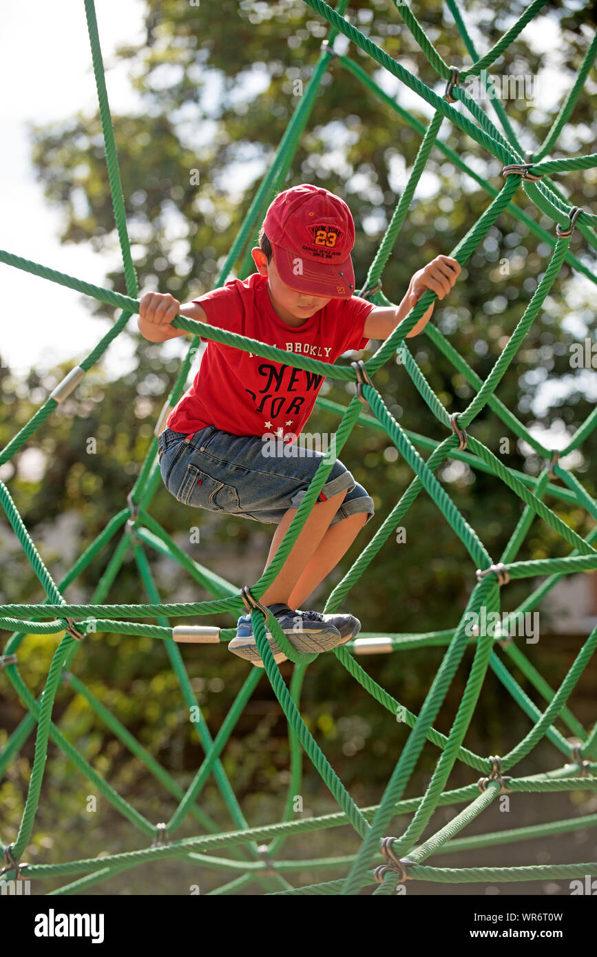 Young boy climbing on a spider web Stock Photo - Alamy