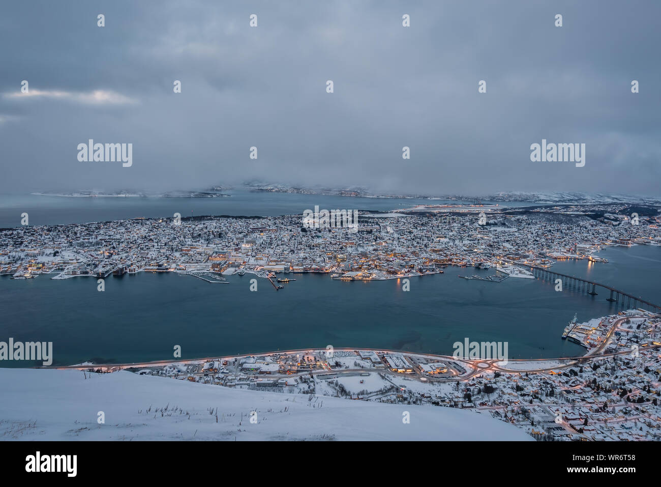 Aerial view to the city of Tromso in winter from the mountain ledge Storsteinen, 421 m above sea ...