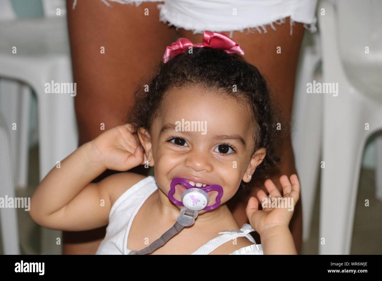 Cute baby with pacifier looking at the camera hi-res stock photography ...