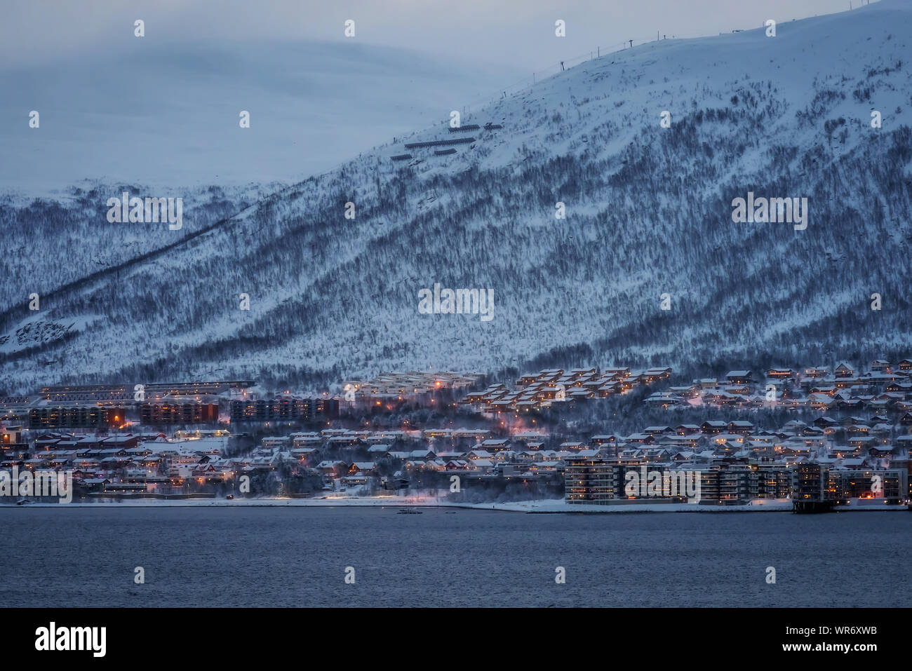 Residential hillside houses in Tromso suburb covered in a deep snow at ...