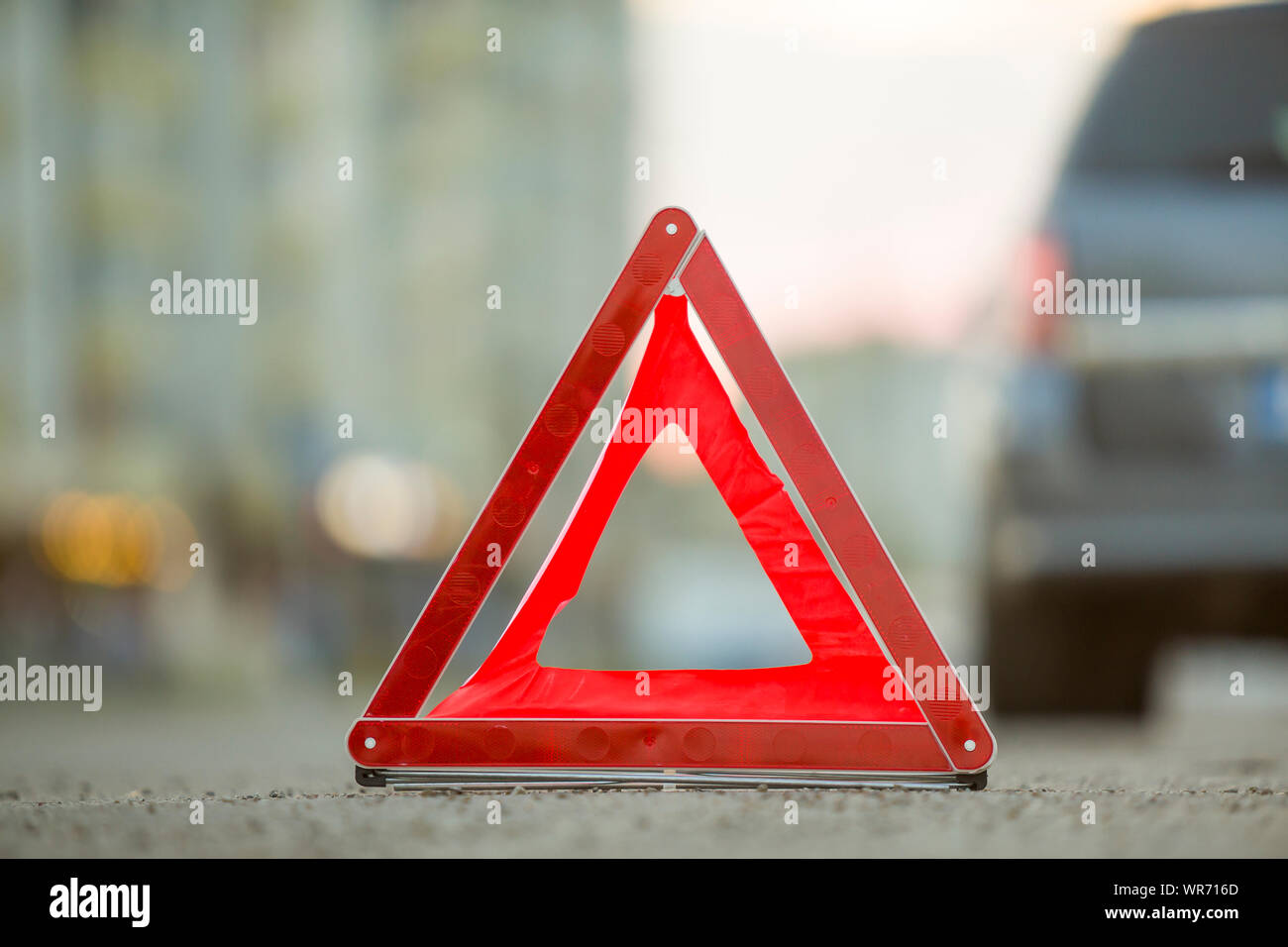 Red emergency triangle stop sign and broken car on a city street Stock ...