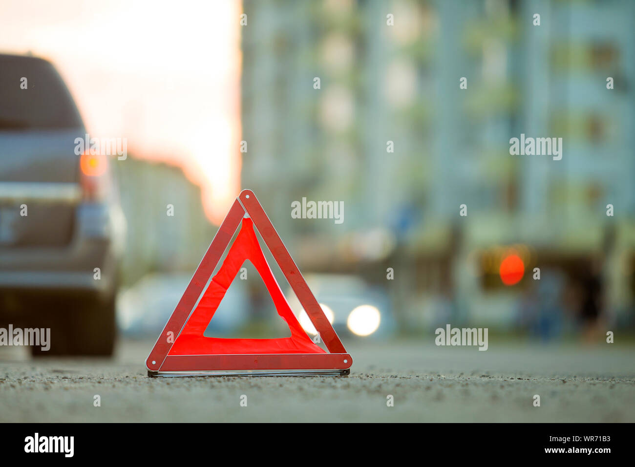 Red emergency triangle stop sign and broken car on a city street Stock ...