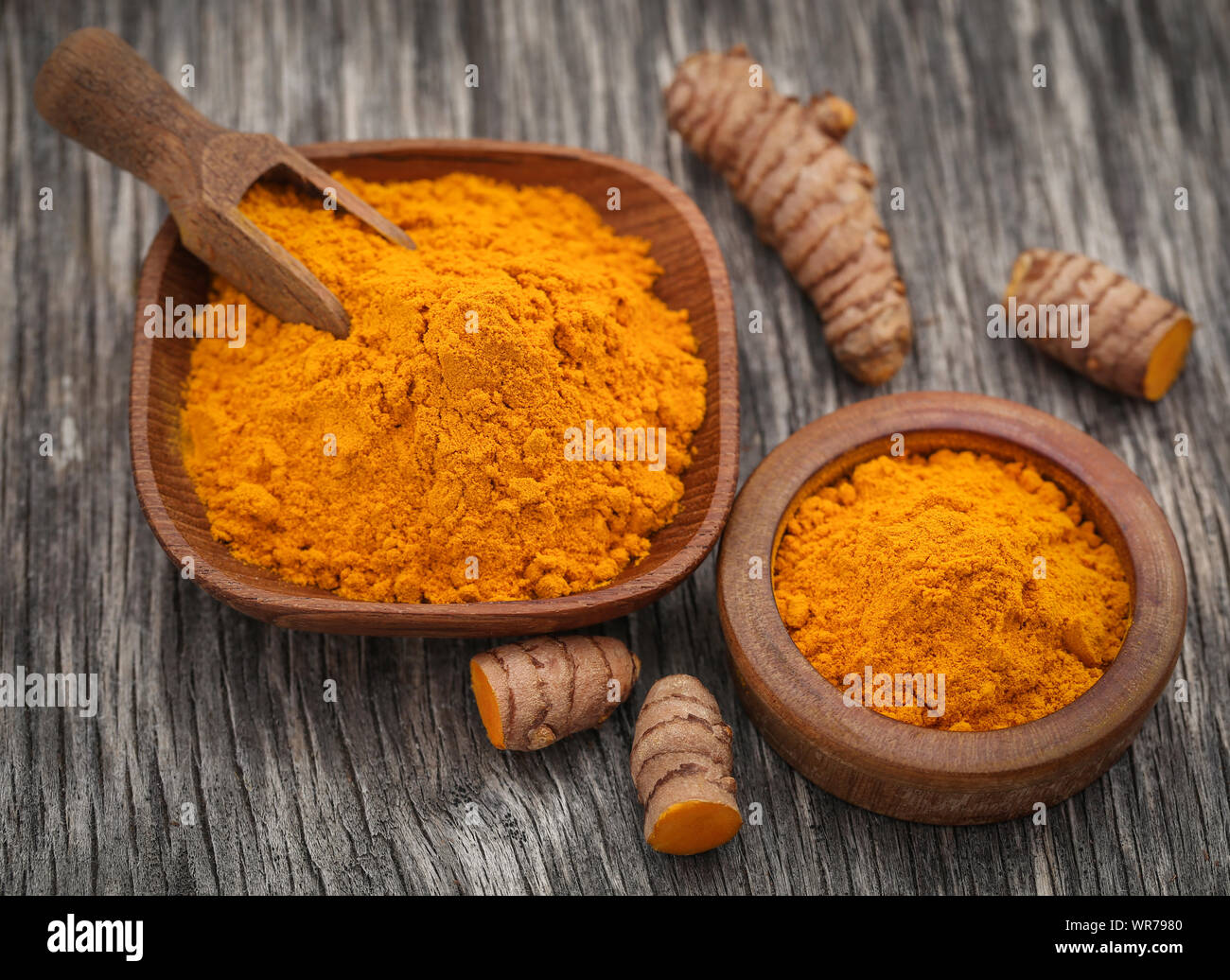 Raw turmeric with powder in wooden bowl Stock Photo - Alamy