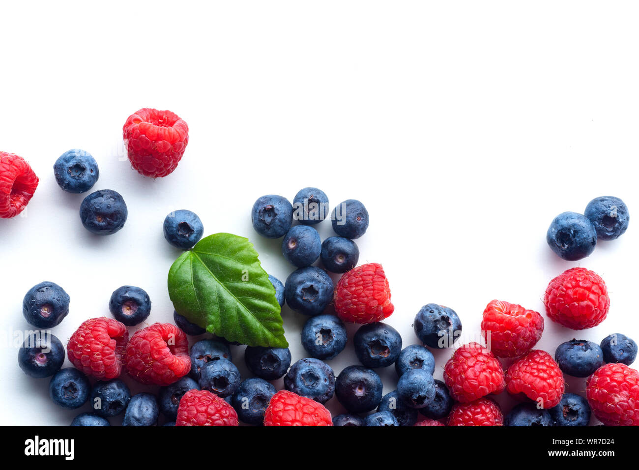 Raspberries and blueberries isolated on white background with copy ...