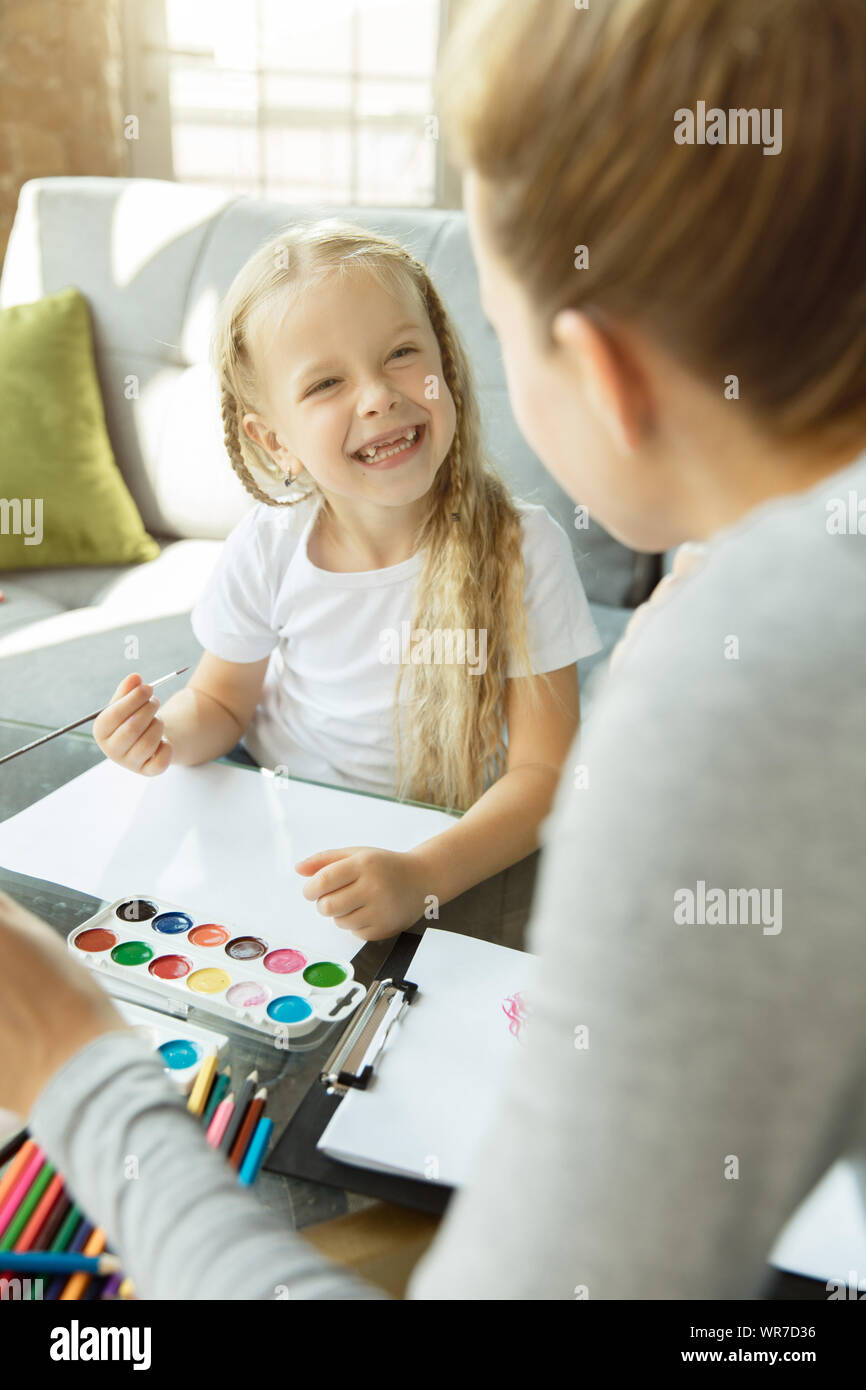 Draw your dream. Female caucasian teacher and little girl, or mom and ...