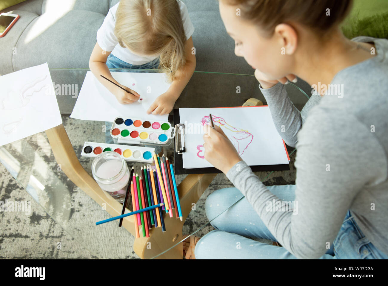 Draw your dream. Female caucasian teacher and little girl, or mom and ...