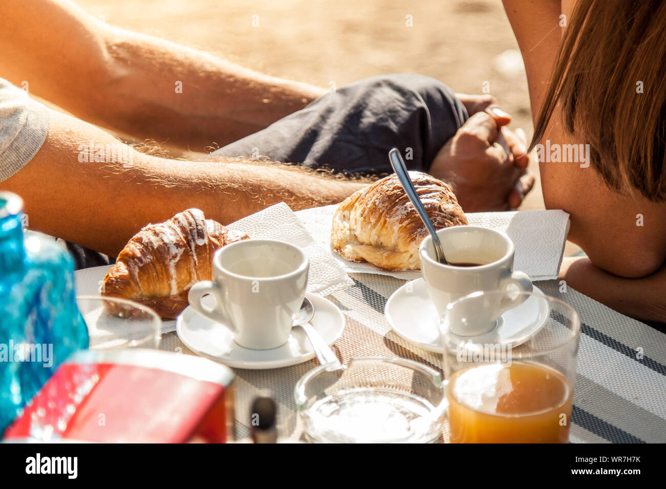 Coffee cups, cornetto and juice glass on a bar table outside in Rome ...