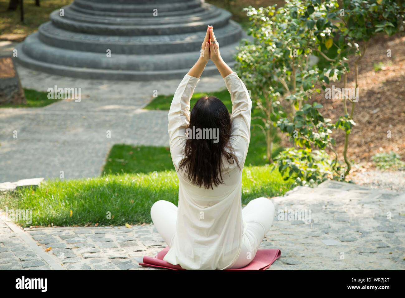 Woman sitting in yoga pose view from the back. Meditation on the ...