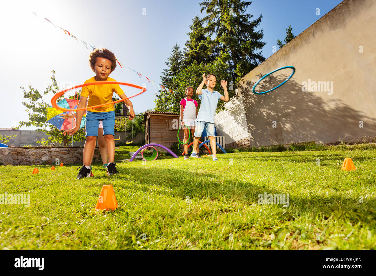Little boy throw color hula hoop to target cone Stock Photo - Alamy
