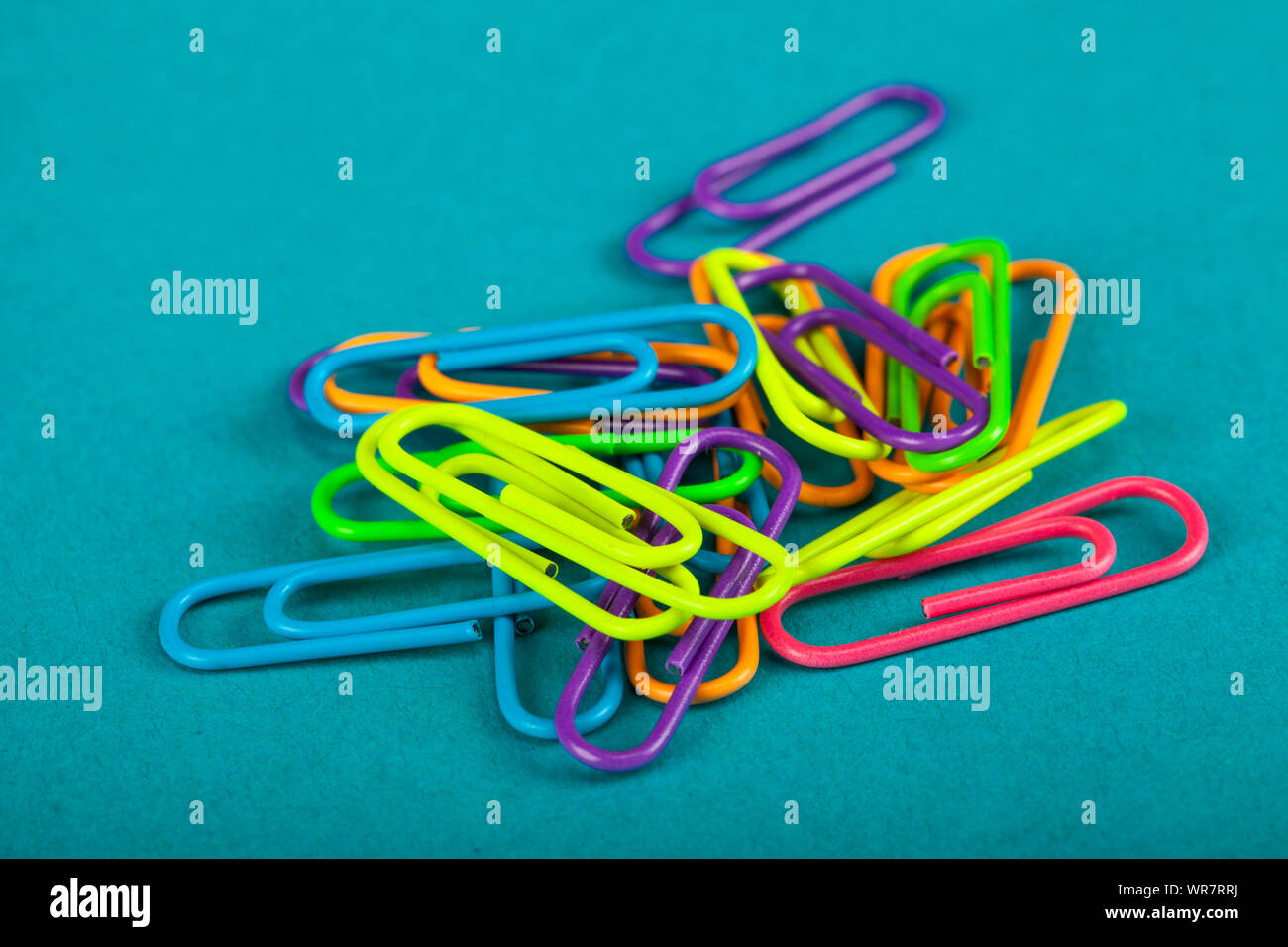 Colorful paperclips on blue background Stock Photo - Alamy
