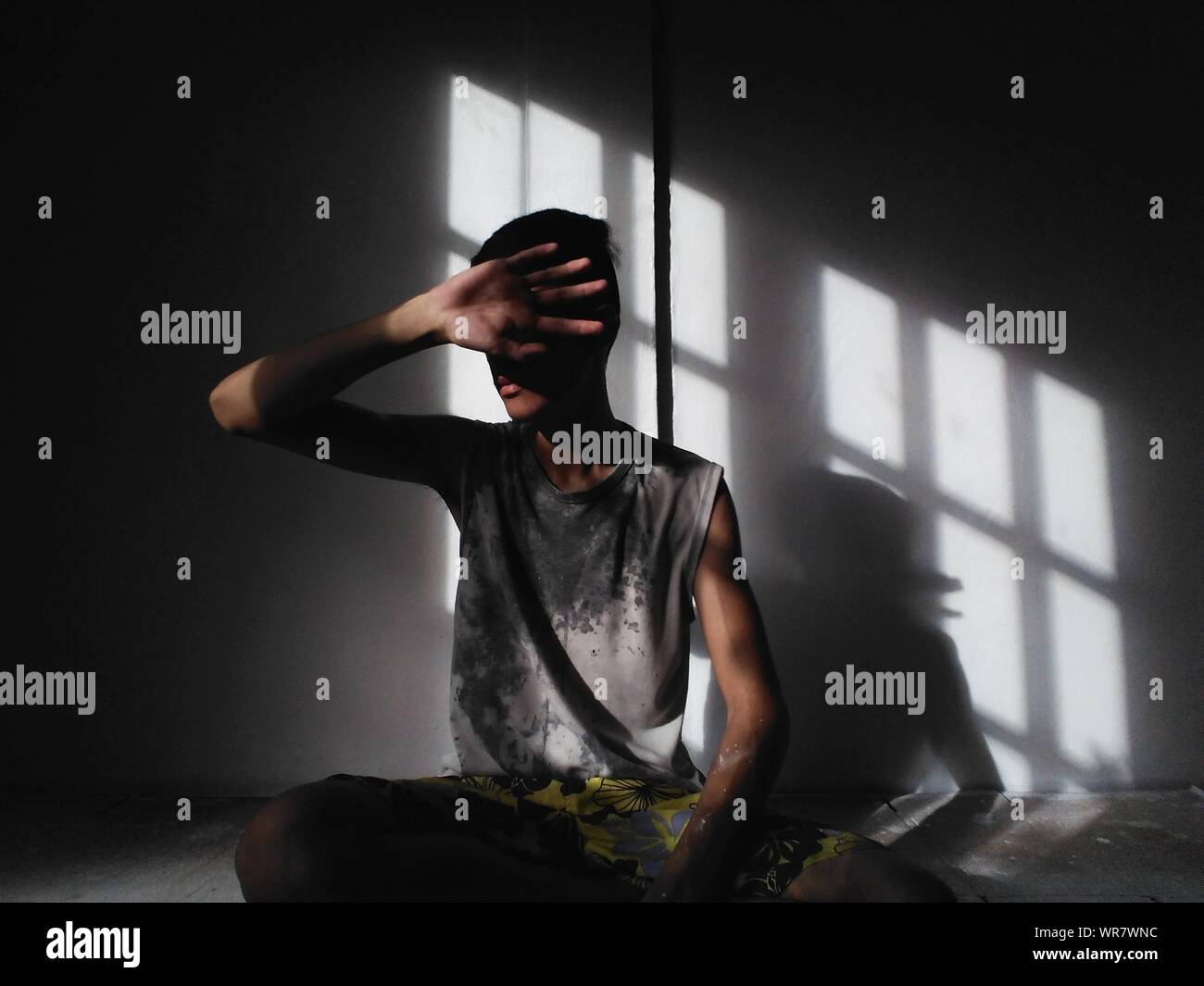 Man sitting against wall hands hi-res stock photography and images - Alamy