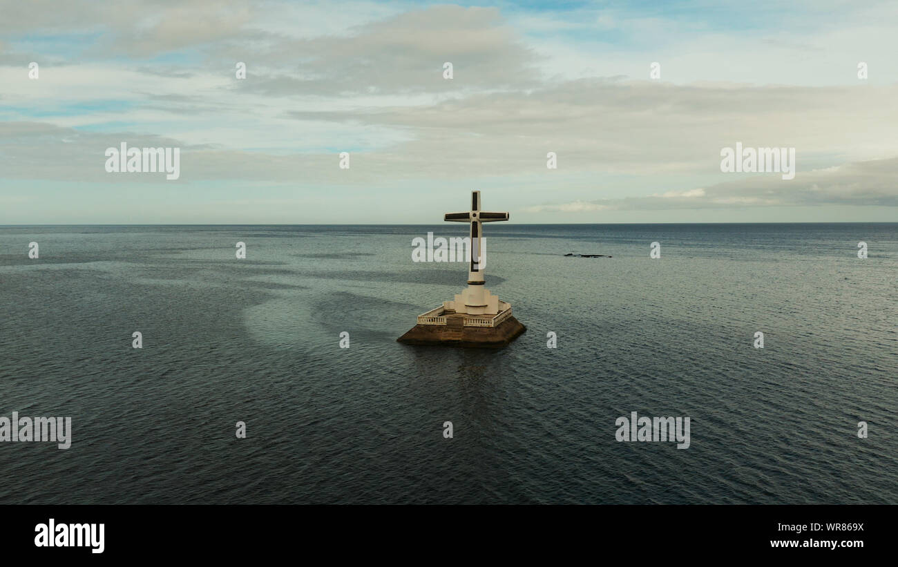 Catholic cross in sunken cemetery in the sea at sunset, aerial view ...