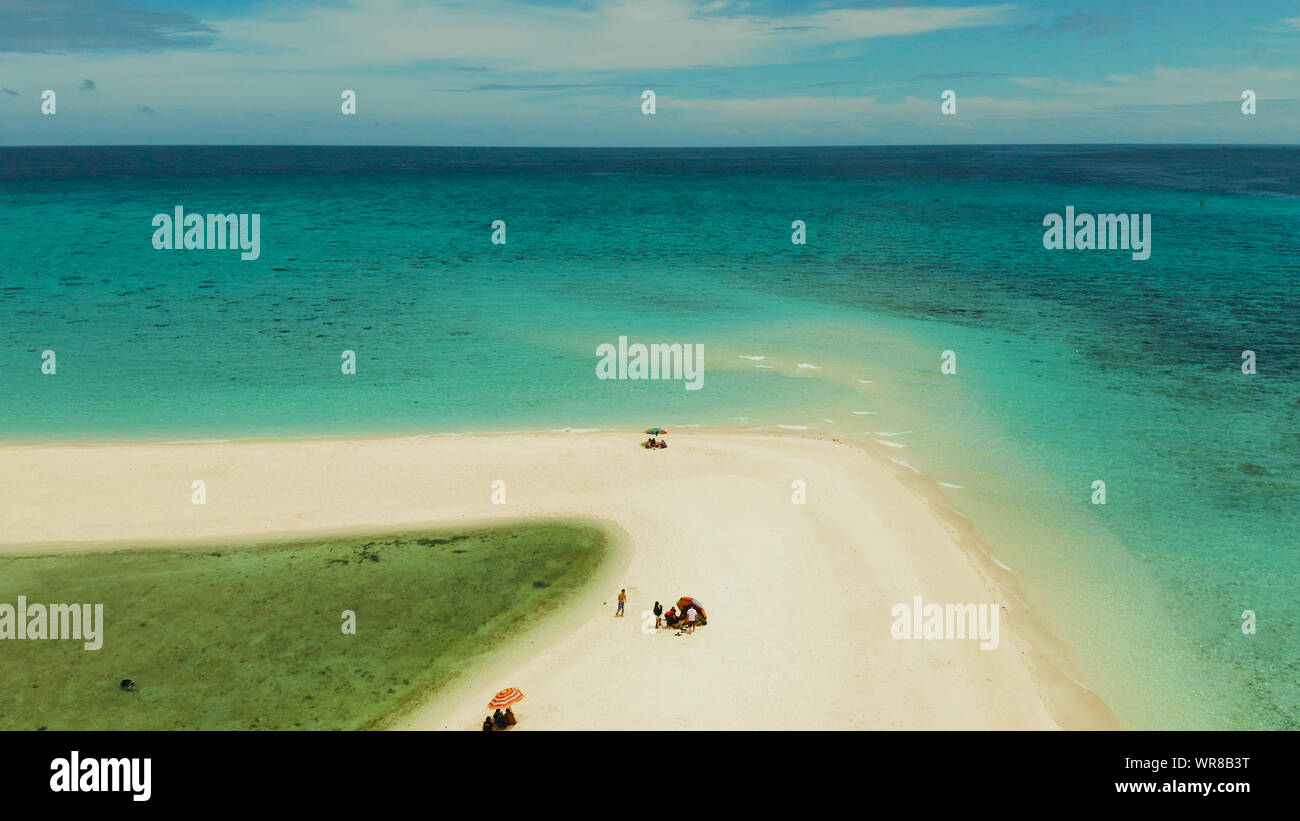 Tropical white island and sandy beach with tourists surrounded by coral ...