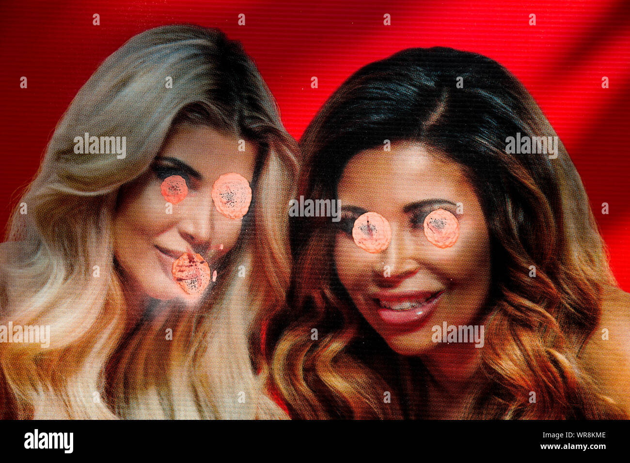 The faces of women on a poster daubed with paint Stock Photo - Alamy