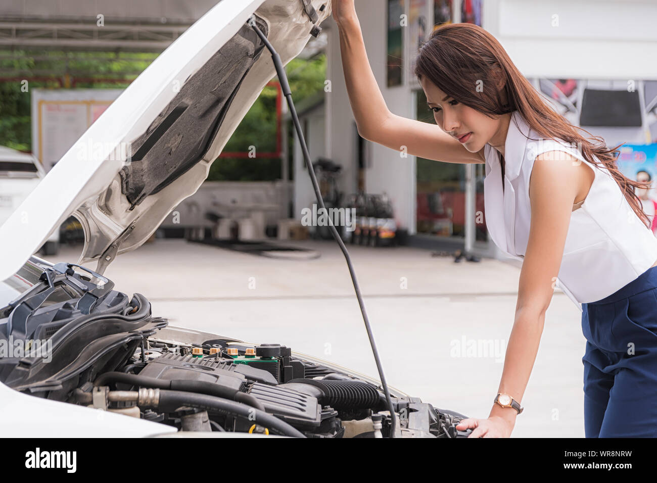 Asian woman the car is broken. Open the bonnet, check engine Stock ...