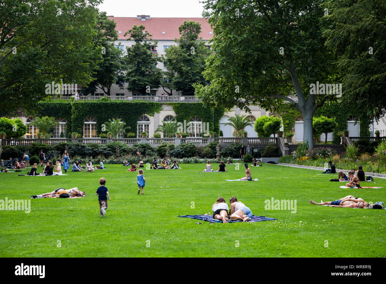 People relax on a summer's day in Kornerpark in the Neukolln area of ...