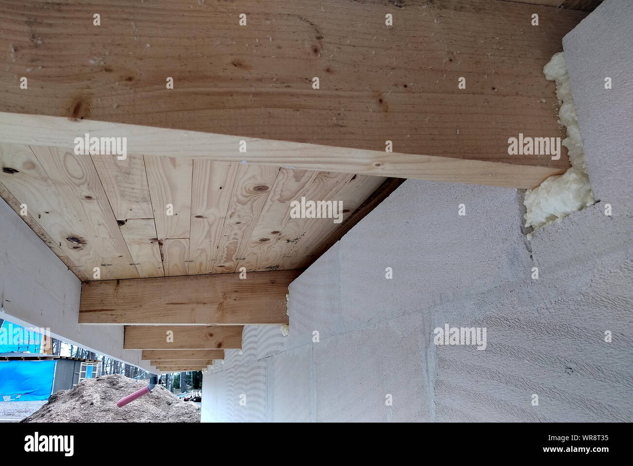 Installation of wooden beams of roof frame with spray foam on a house ...