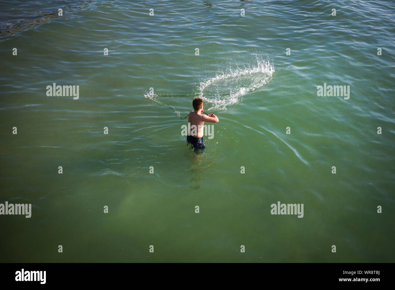 A boy uses a fishing net in the sea at Naples, Florida, USA Stock Photo ...