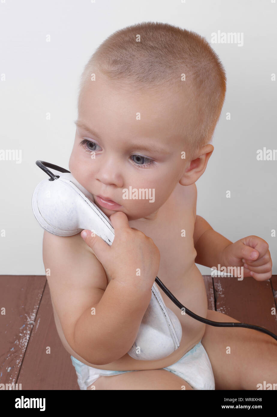Portrait of the thoughtful little boy speaking by vintage phone on a ...