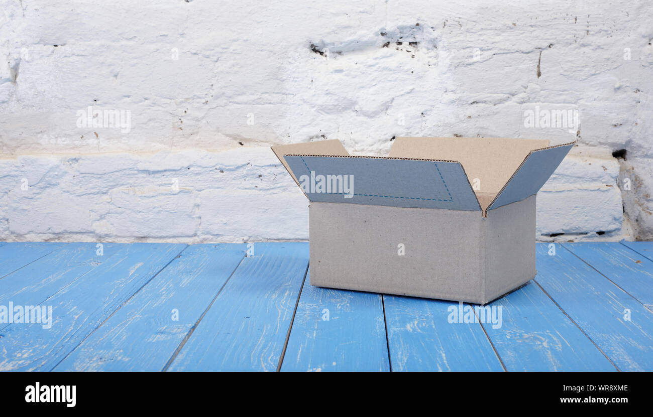 Postage and packing service - Open Package front view on a blue wood ...