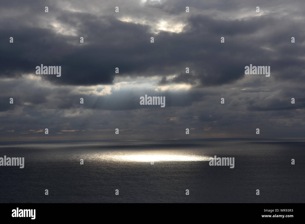 a sunbeam that sneaks through the clouds and goes to the sea in Cabo ...