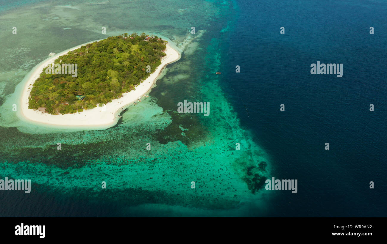 Small tropical island on an atoll with beautiful sandy beach surrounded ...