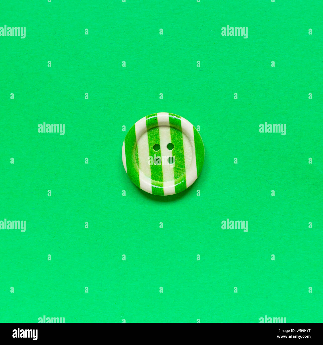 Single green sewing button with stripes on green background Stock Photo ...