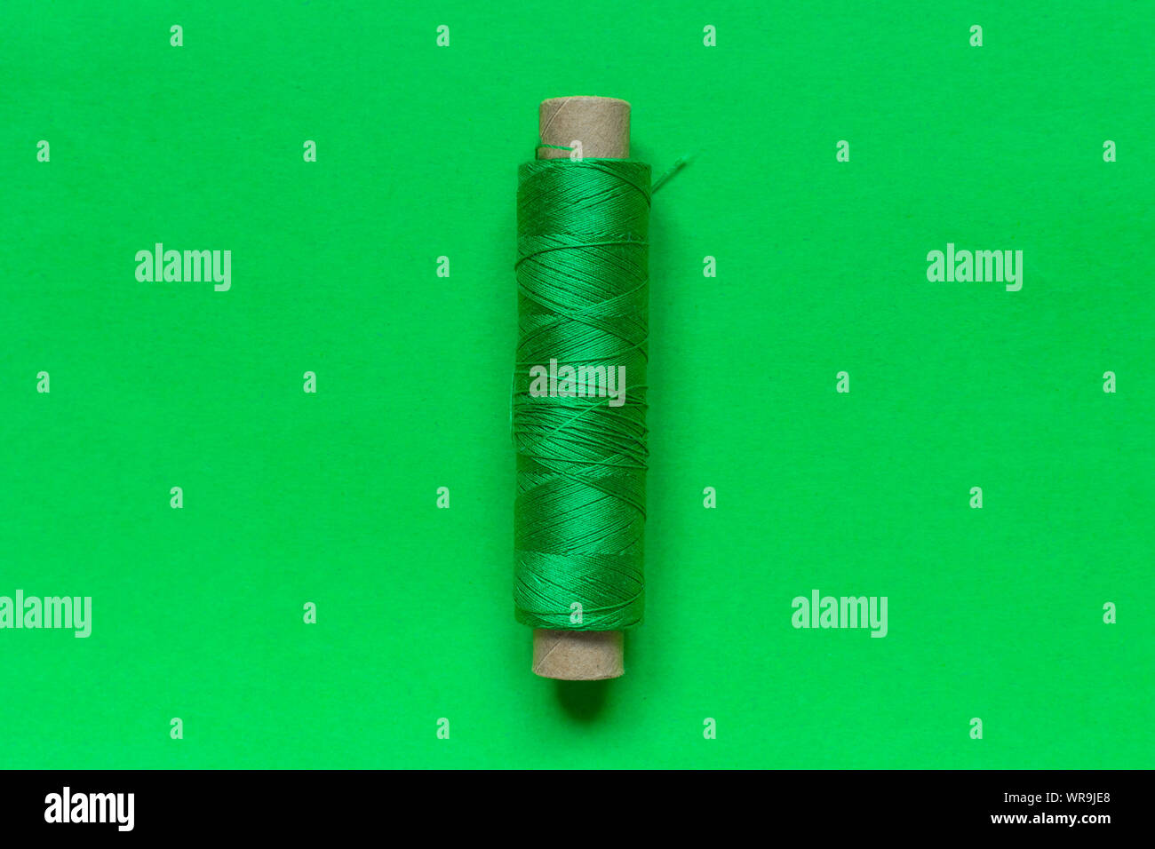 Green thread on green background Stock Photo - Alamy