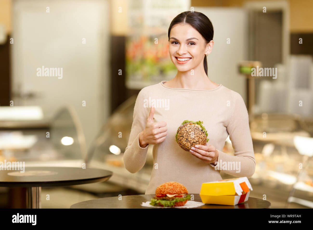 Young woman eating in the supermarket cafeteria Stock Photo - Alamy