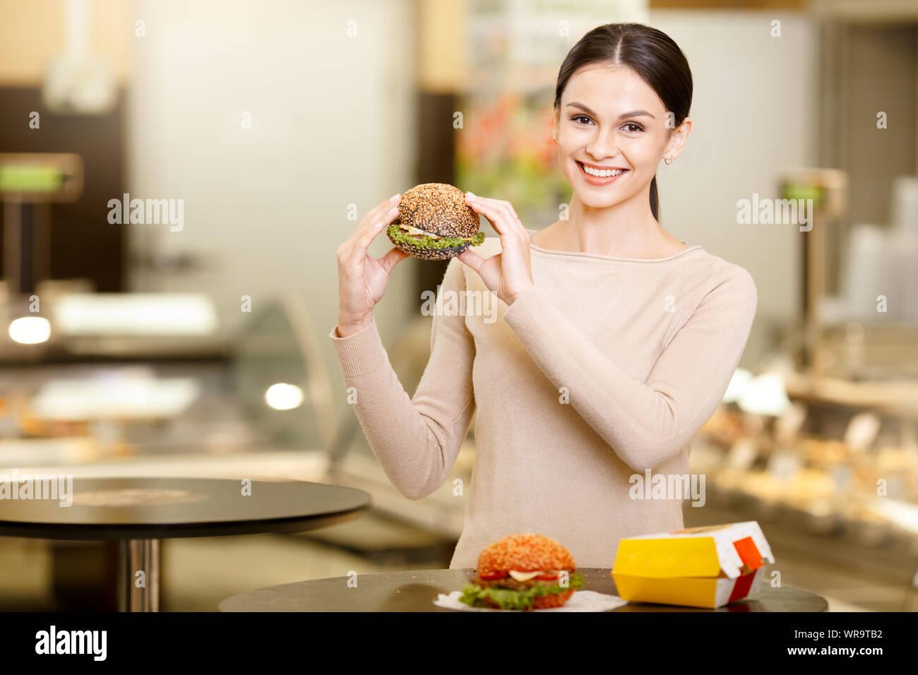 Young woman eating in the supermarket cafeteria Stock Photo - Alamy