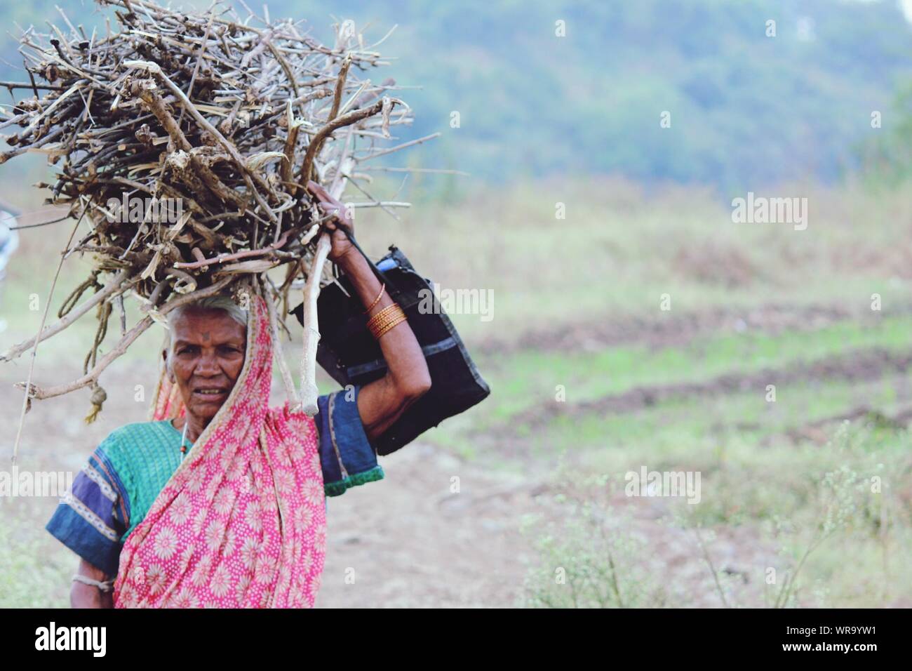 Woman carrying firewood hi-res stock photography and images - Alamy