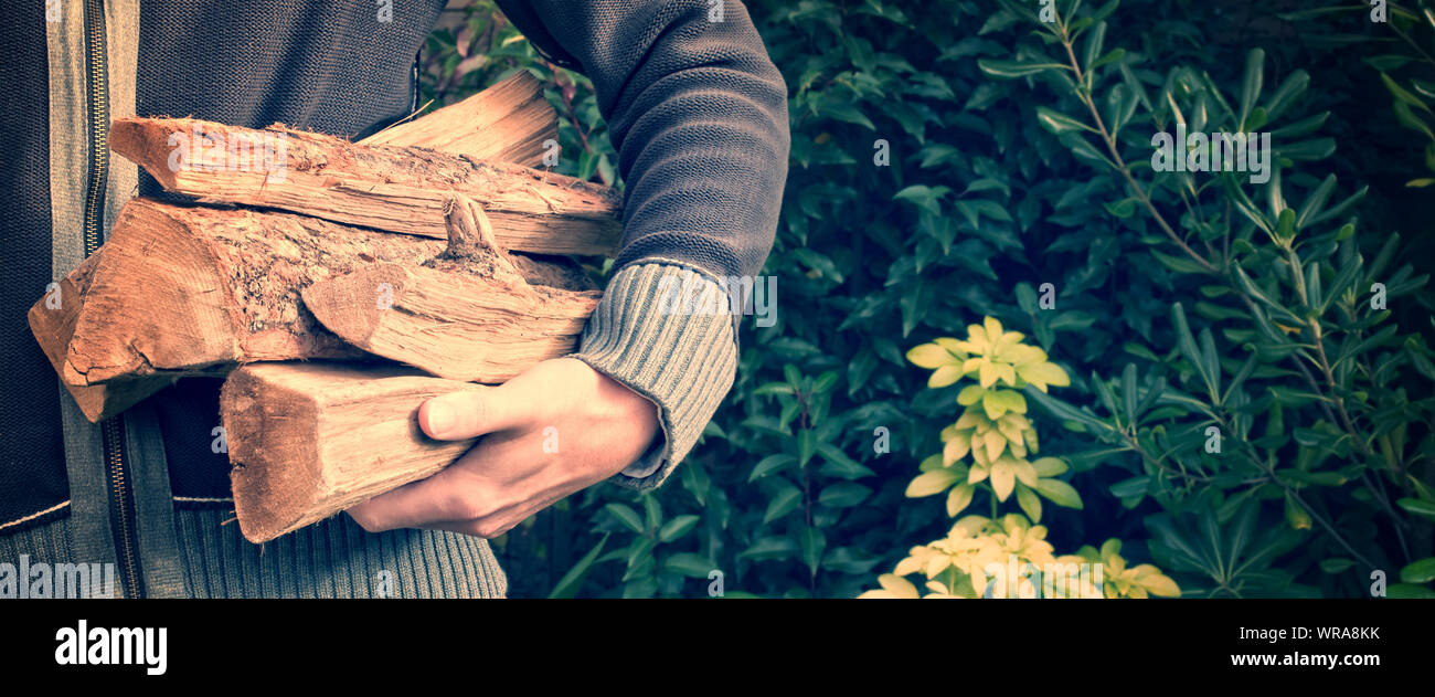Man carrying firewood logs, vintage process Stock Photo - Alamy