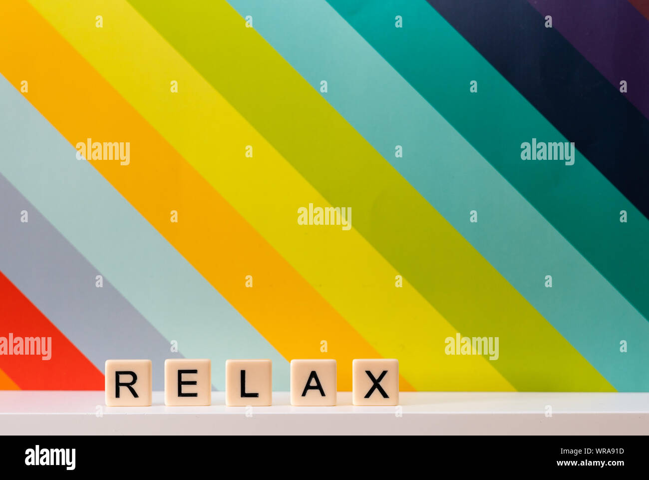 word relax against colourful backdrop Stock Photo - Alamy