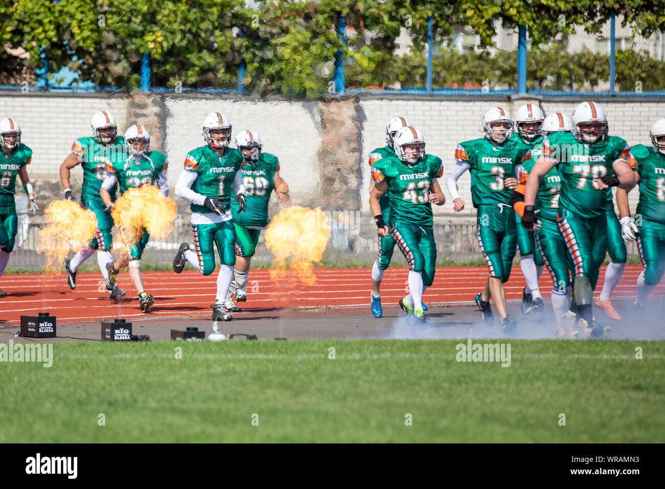 Start of the american football game. show with fire. teams entering the ...