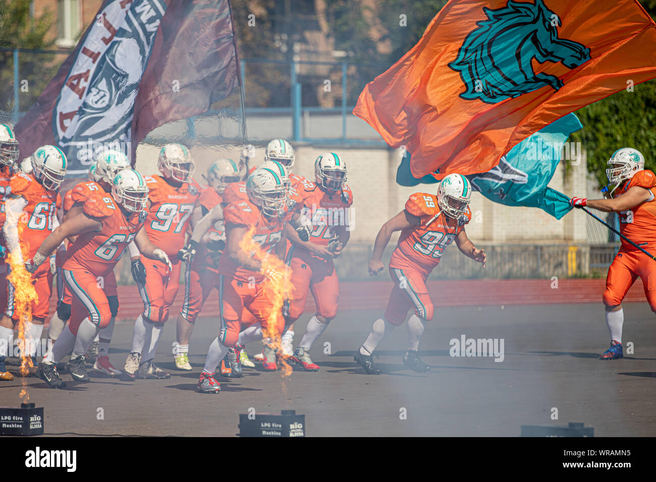 Start of the american football game. show with fire. teams entering the ...